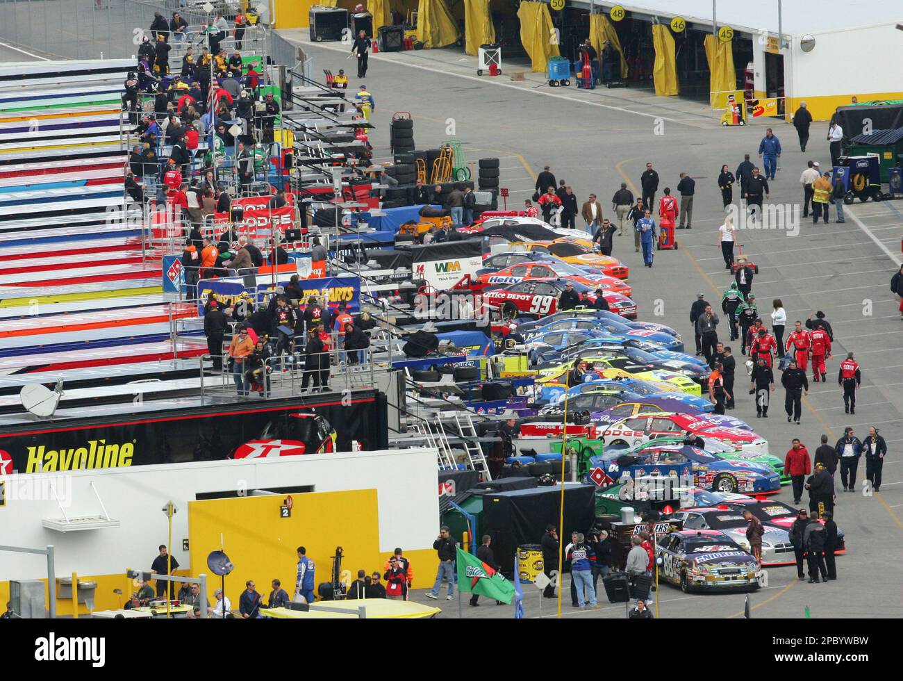 NASCAR race cars are lined up in front of team trucks before the first ...
