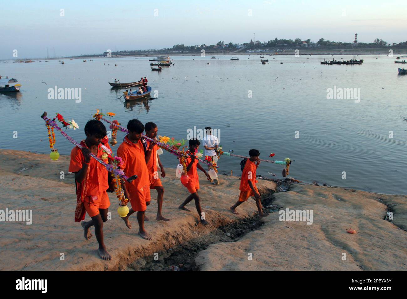Pilgrims carry water from the River Ganges, considered holy by Hindus ...