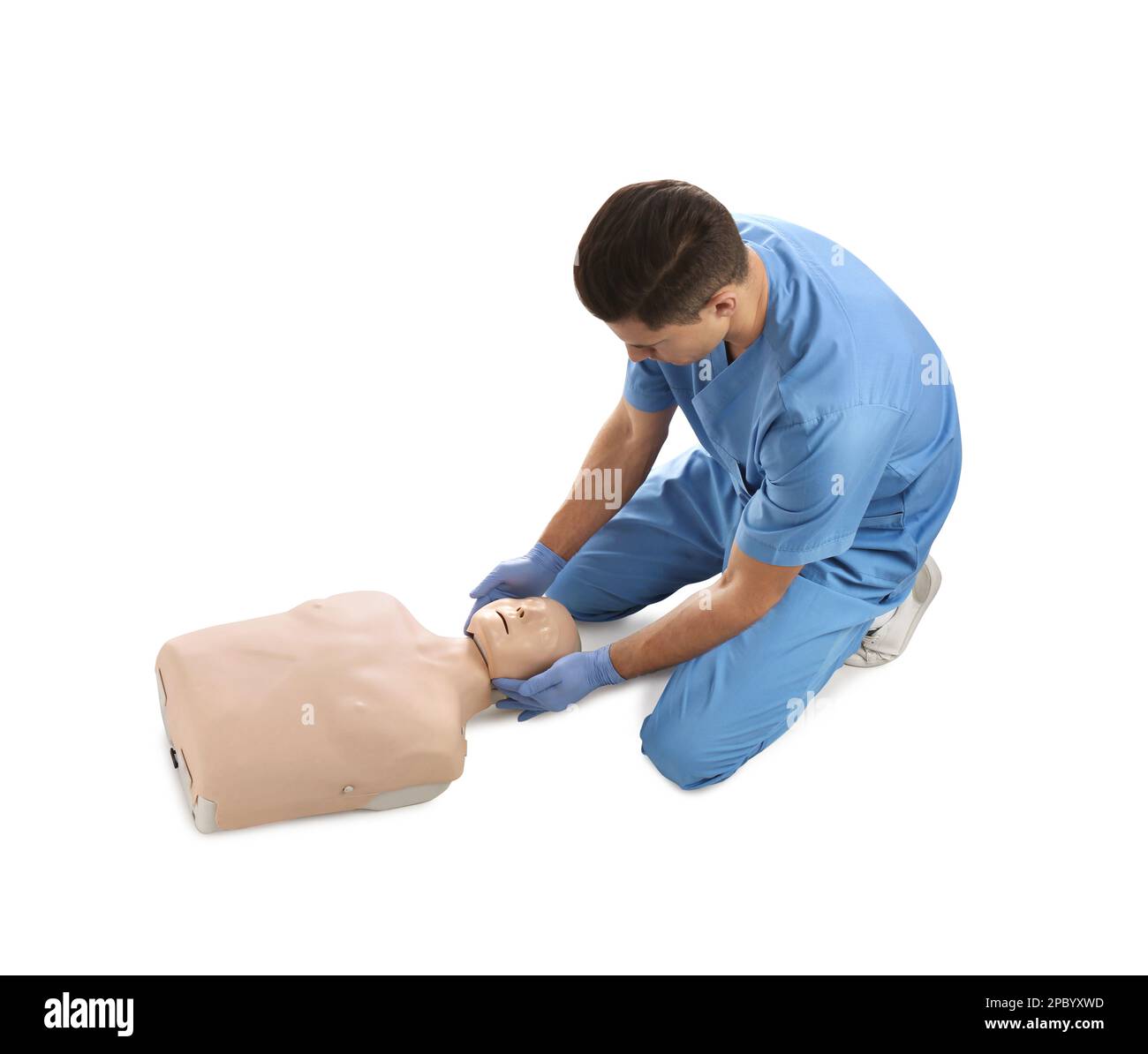 Doctor in uniform practicing first aid on mannequin against white ...