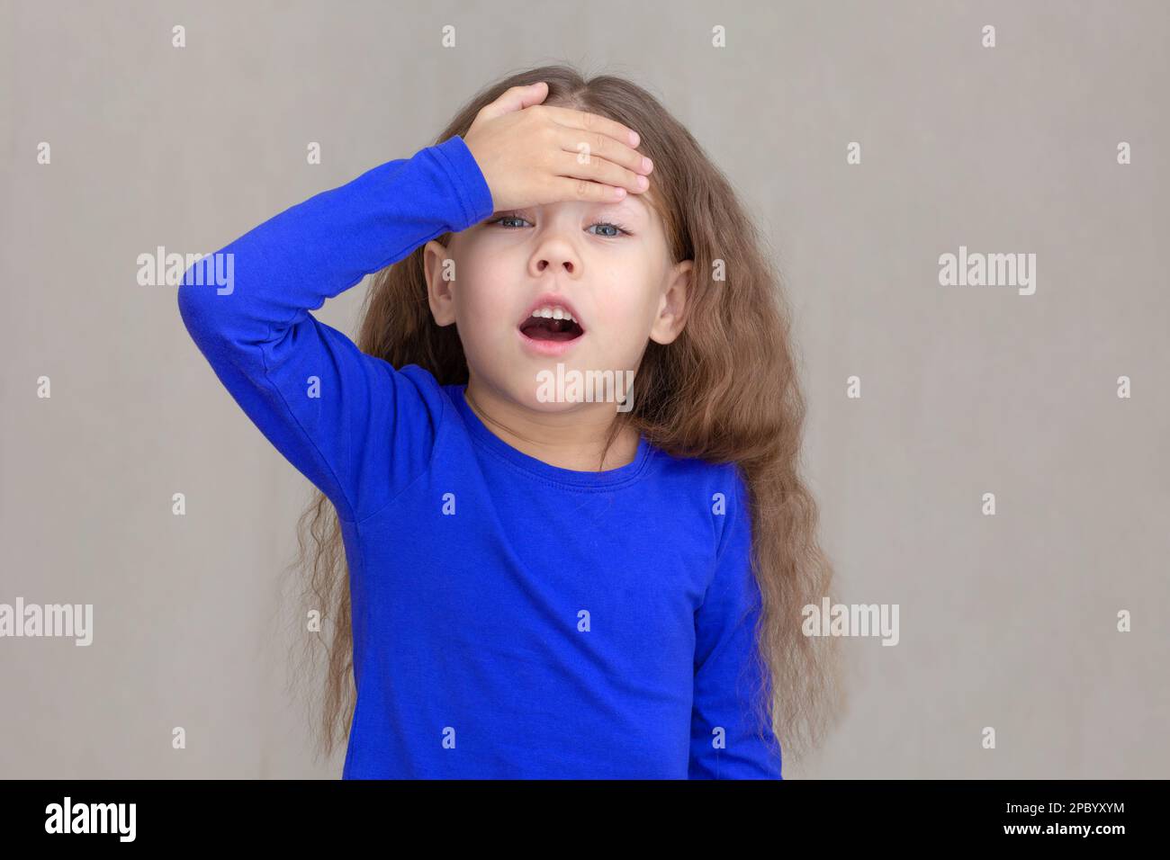 Shocked child kid holding hand on forehead because of surprising ...