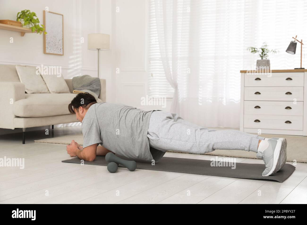 Overweight man doing plank exercise on mat at home Stock Photo - Alamy