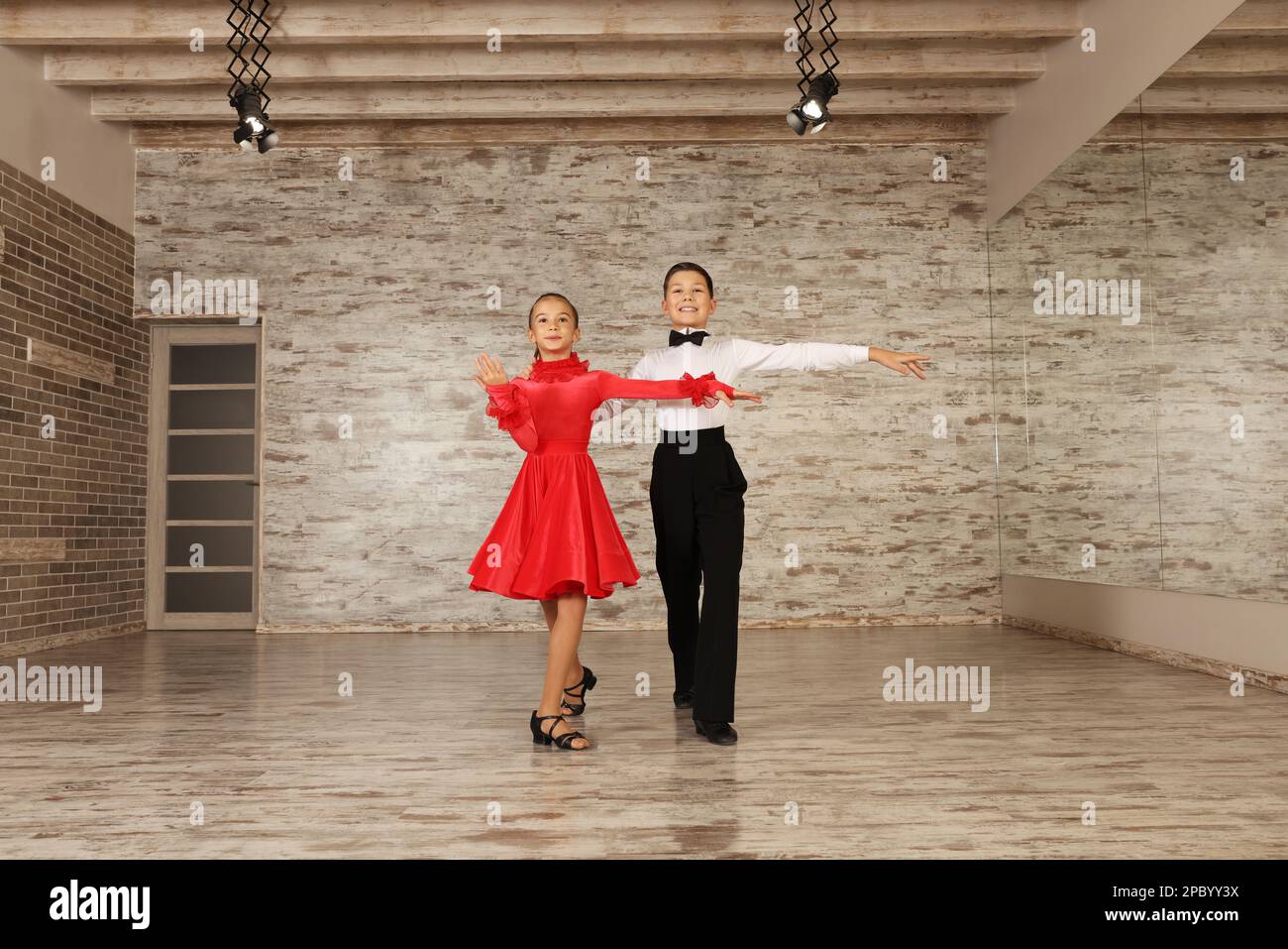 Beautifully dressed couple of kids dancing together in studio Stock ...