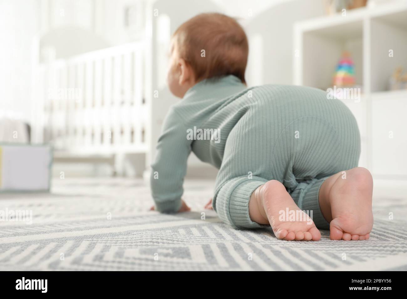 Cute baby crawling on floor at home, back view Stock Photo - Alamy