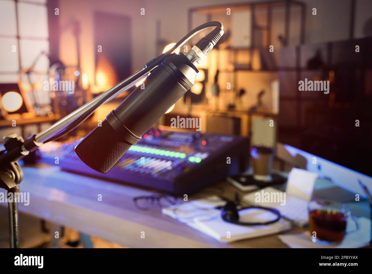 Microphone near table with professional mixing console in radio studio ...