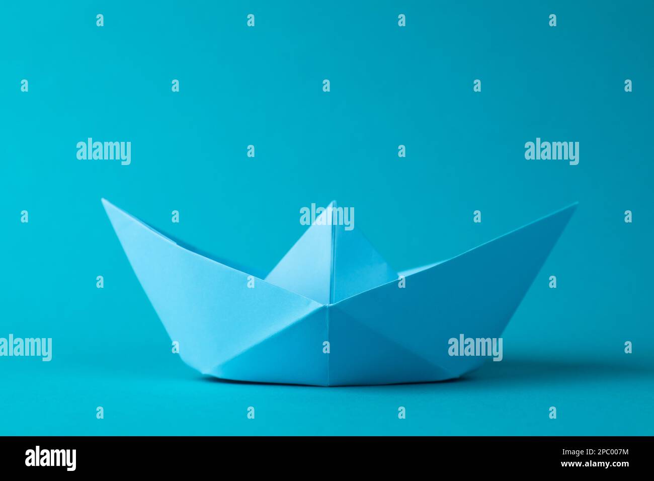 Handmade paper boat on light blue background. Origami art Stock Photo ...