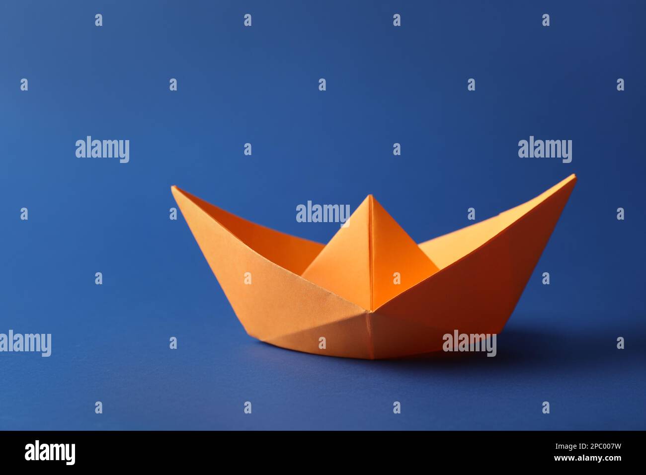 Handmade orange paper boat on blue background. Origami art Stock Photo ...