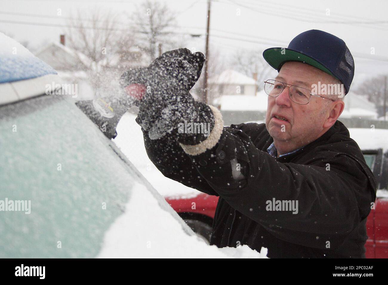 Truman Householder scrapes ice and snow from his truck windshield ...