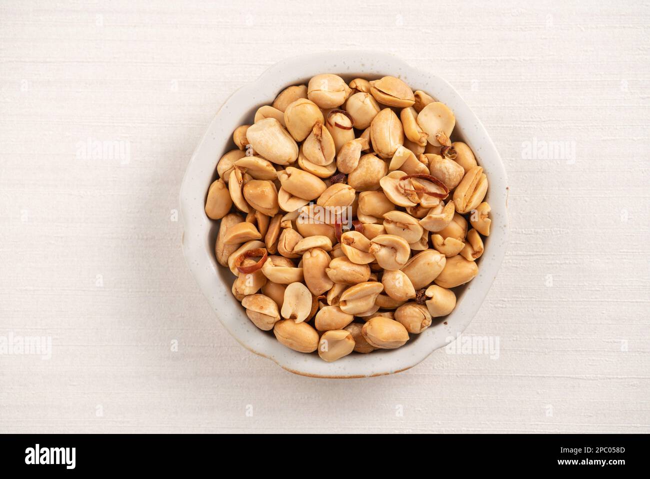 Spicy flavored peanut kernel in a bowl on white table background Stock ...