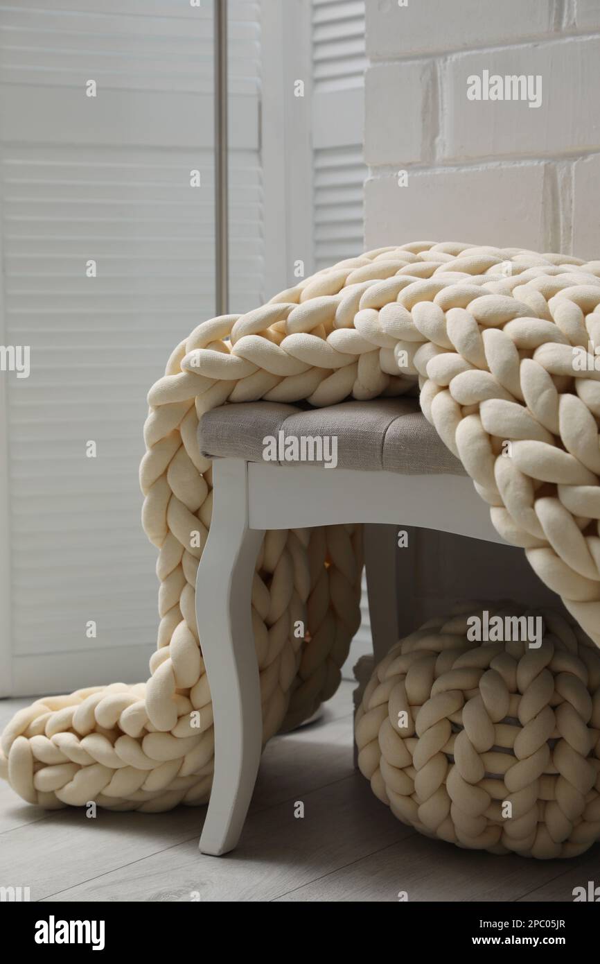 Indoor bench with soft chunky knit blanket and pouf in room. Interior ...