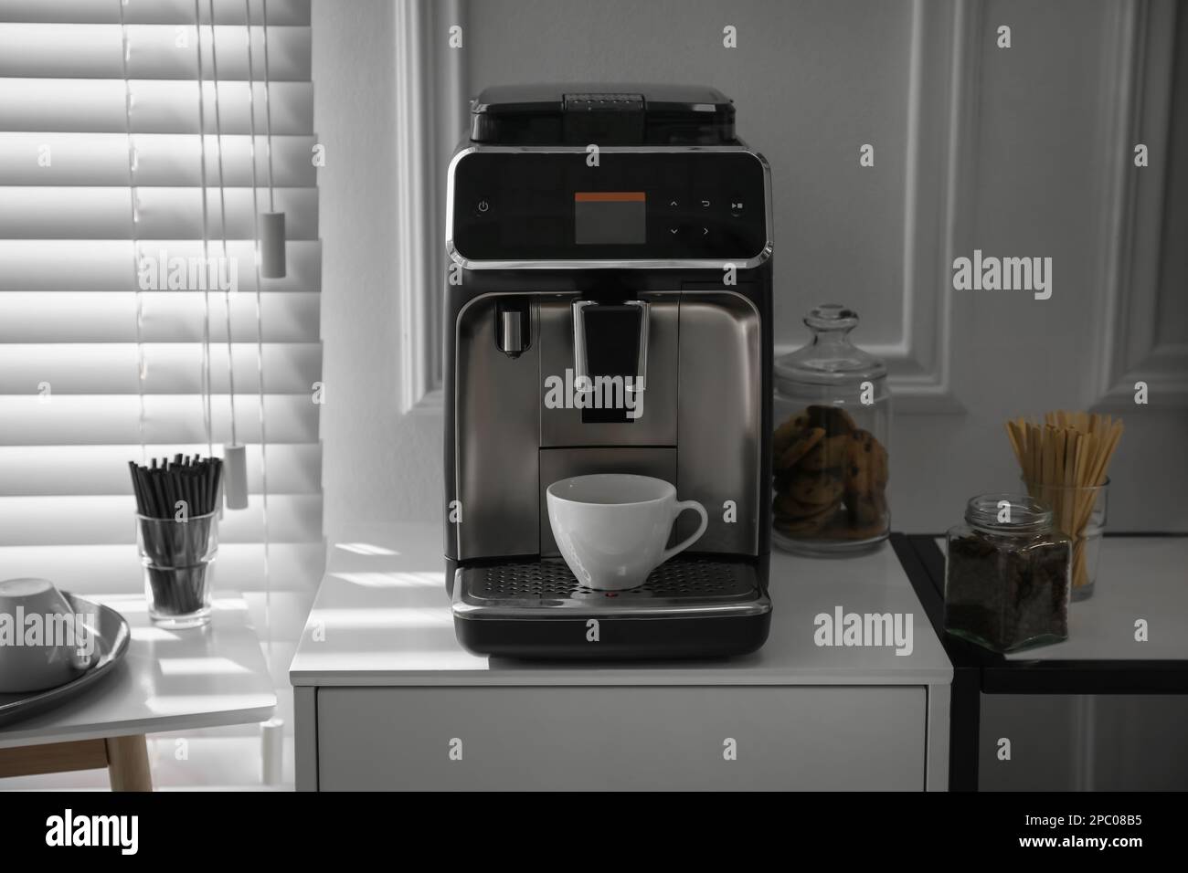 Modern coffee machine with cup in office Stock Photo - Alamy