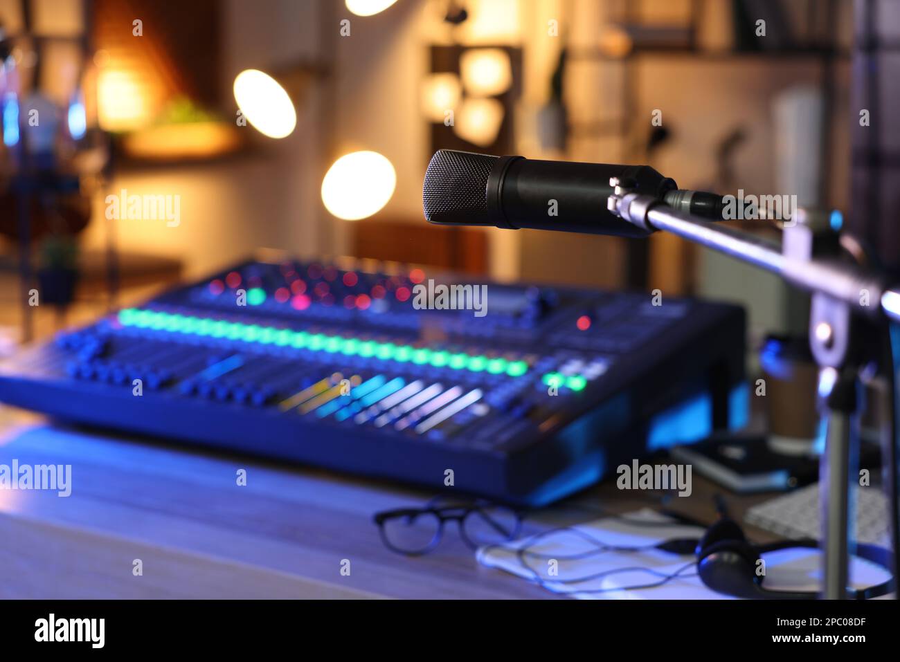 Microphone near table with professional mixing console in radio studio ...