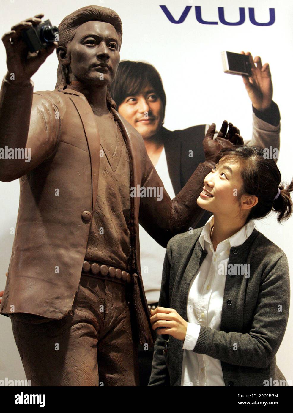 A South Korean woman looks at a life size statue of South Korea actor ...