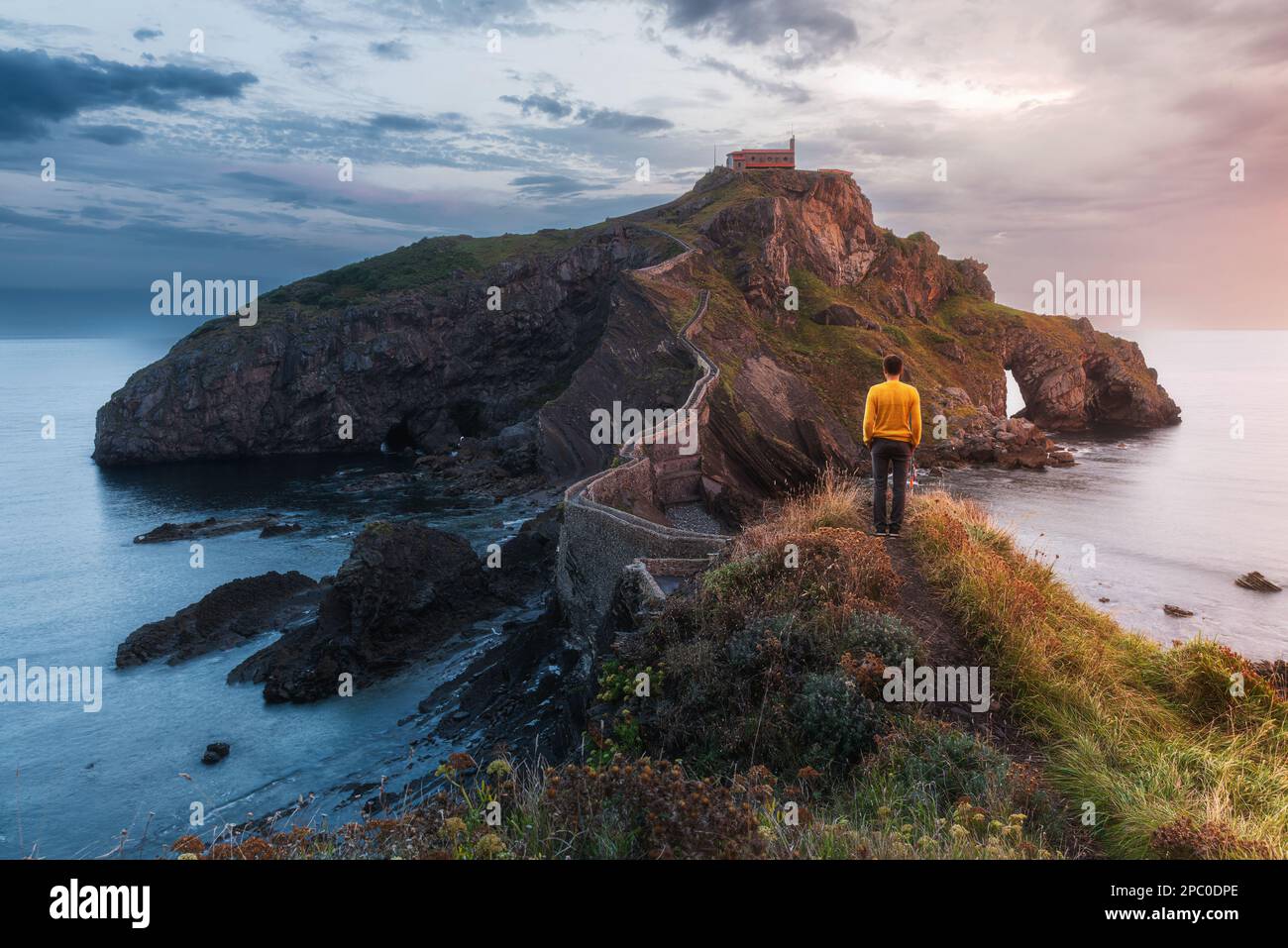 Traveler man in San Juan de Gaztelugatxe island with church at Basque ...