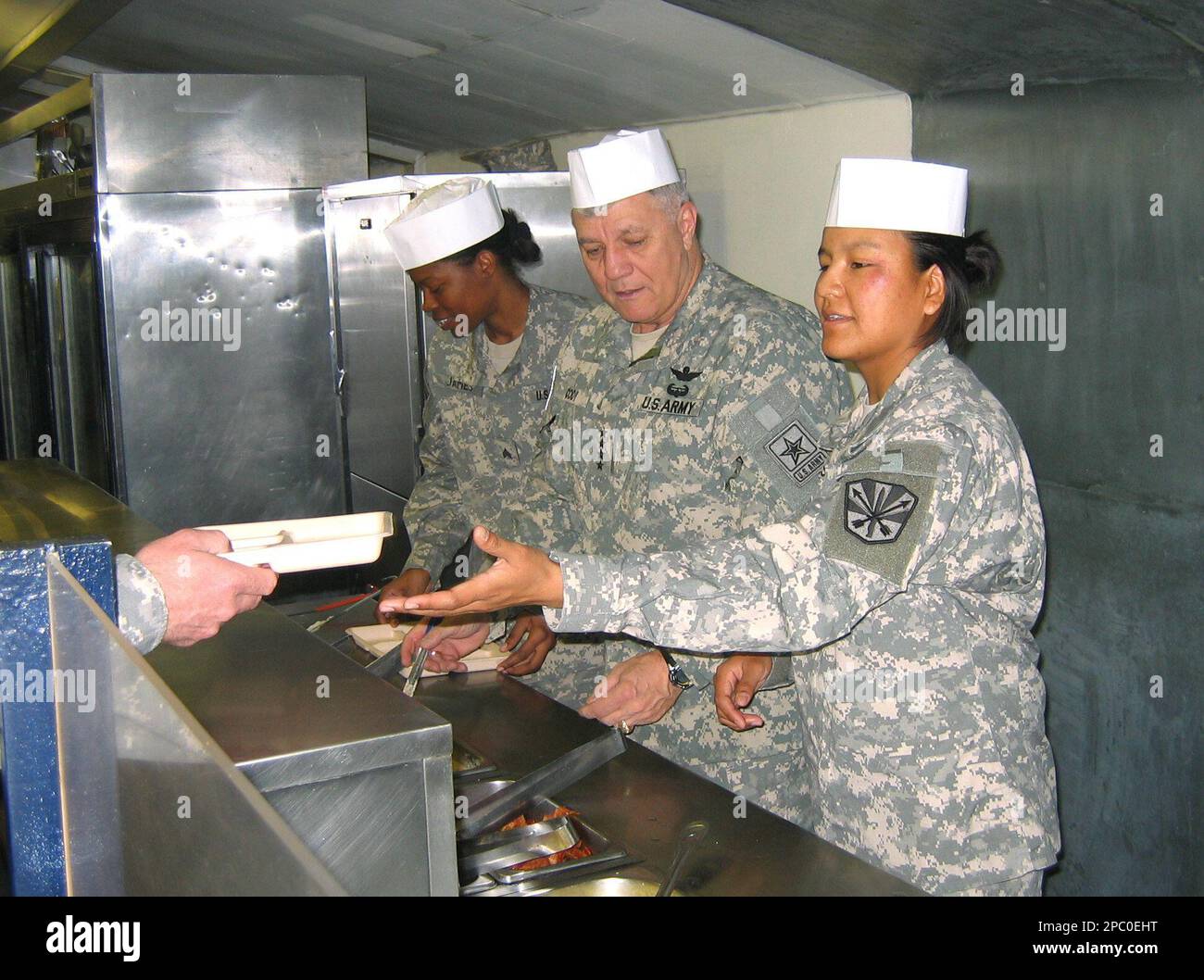 Gen. Richard Cody, the Army's vice chief of staff, center, helps serve ...