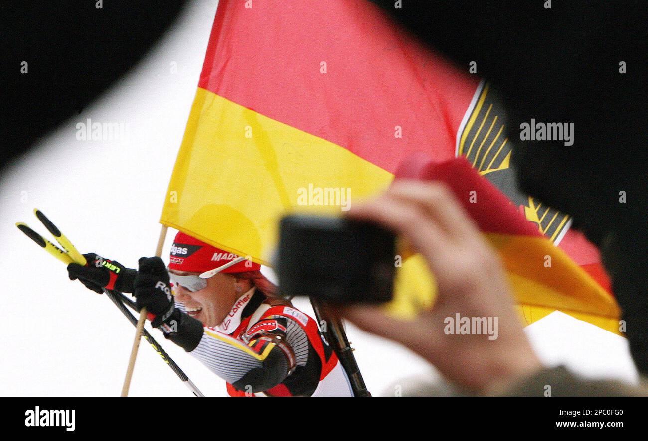 Germany's Kati Wilhelm waves the German flag as she crosses the finish ...