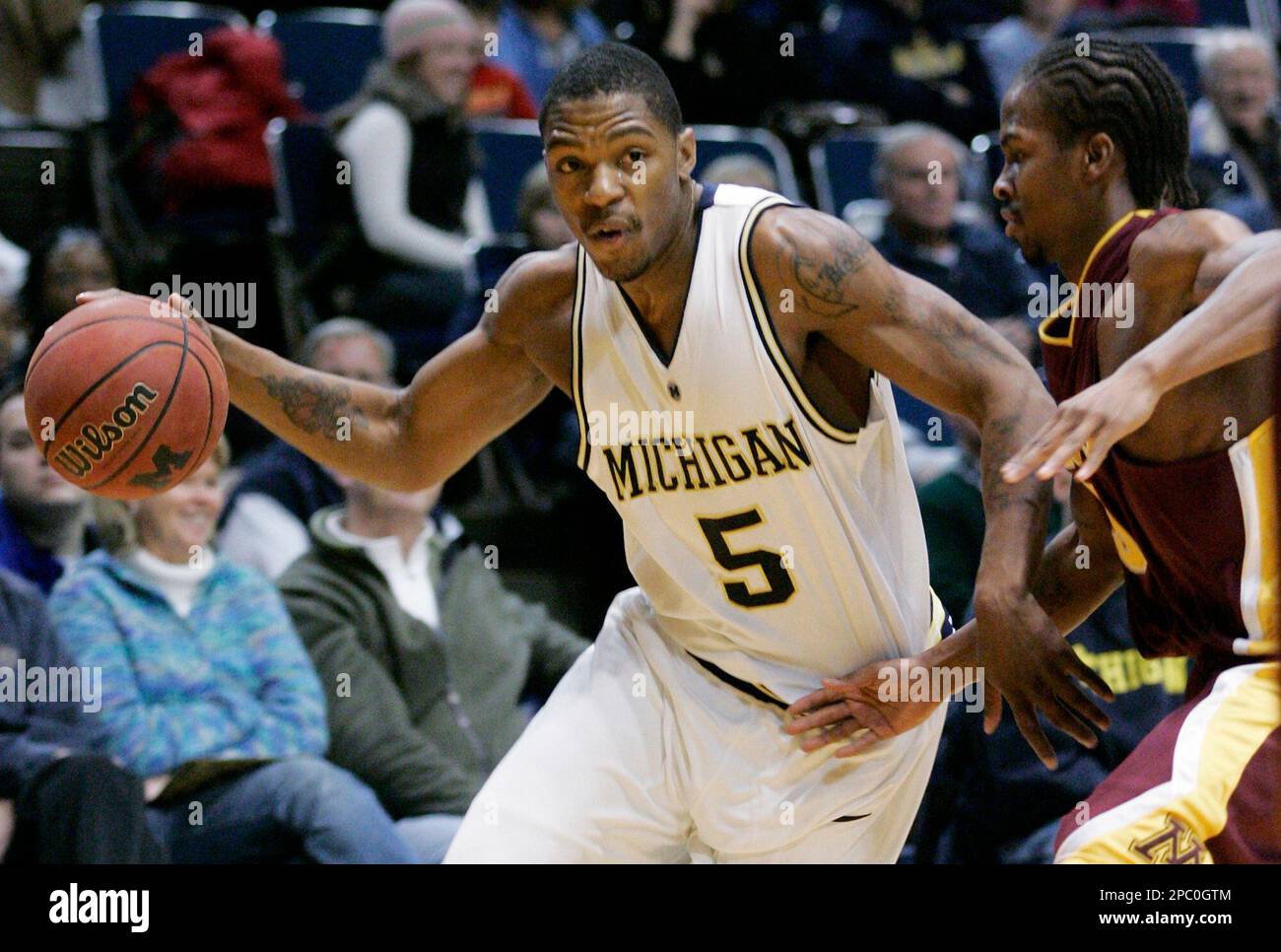 Michigan guard Dion Harris (5) drives past Minnesota guard Limar Wilson ...
