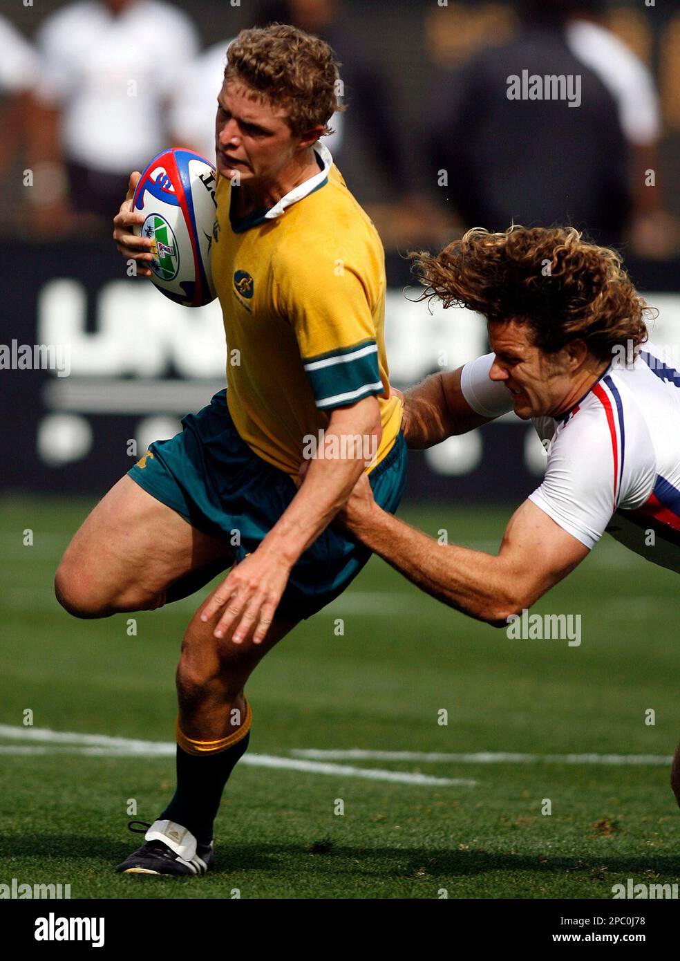 Australia's Nick Cummins, left, breaks past USA's Todd Clever, right ...