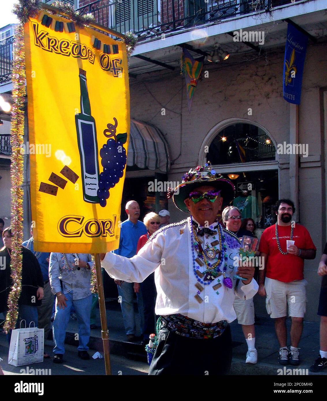 Krewe of Cork masked flag carrier Ron Gagne stands on Royal Street as ...