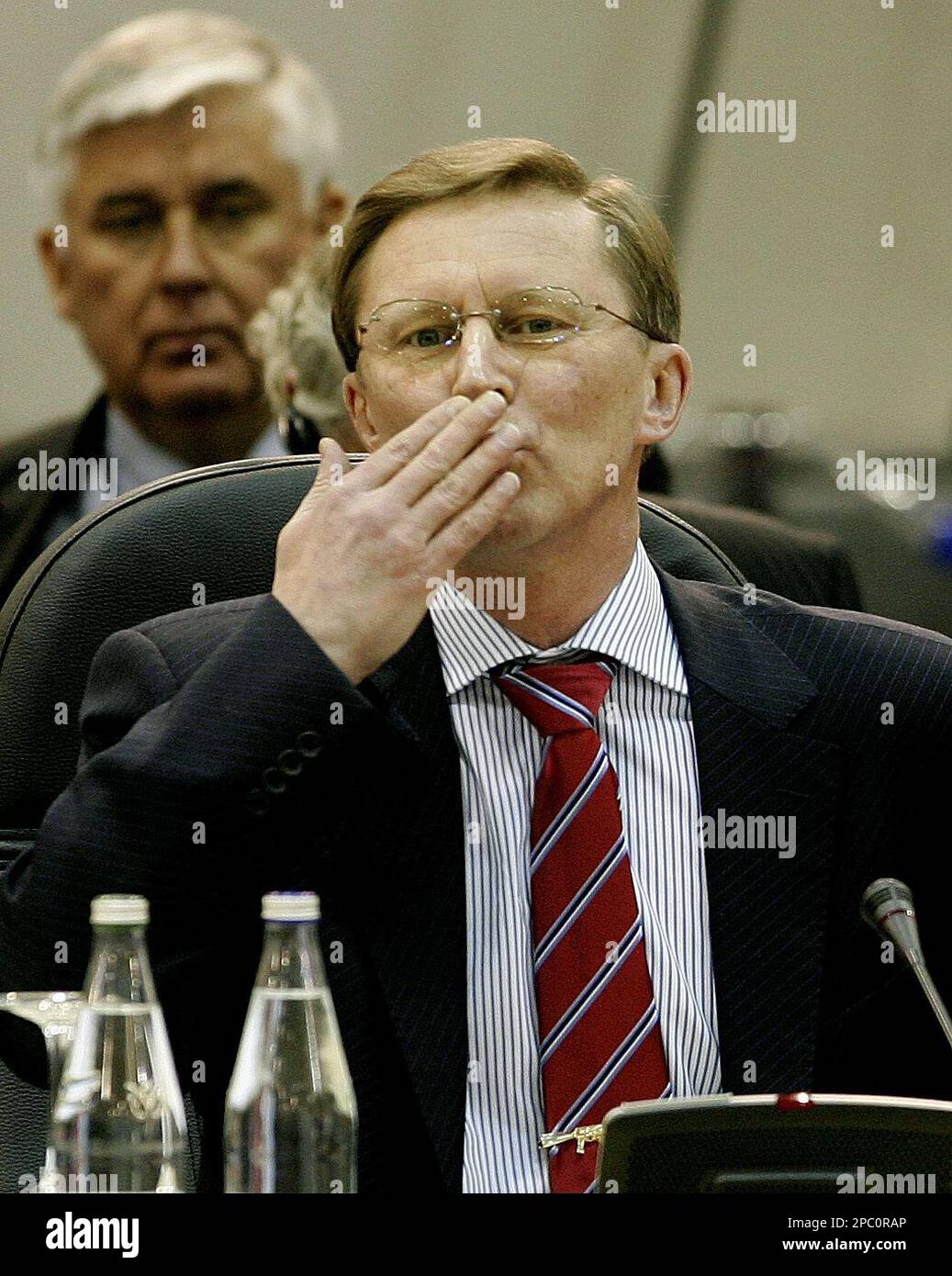 Russian Defense Minister Sergei Ivanov gestures across the table to ...