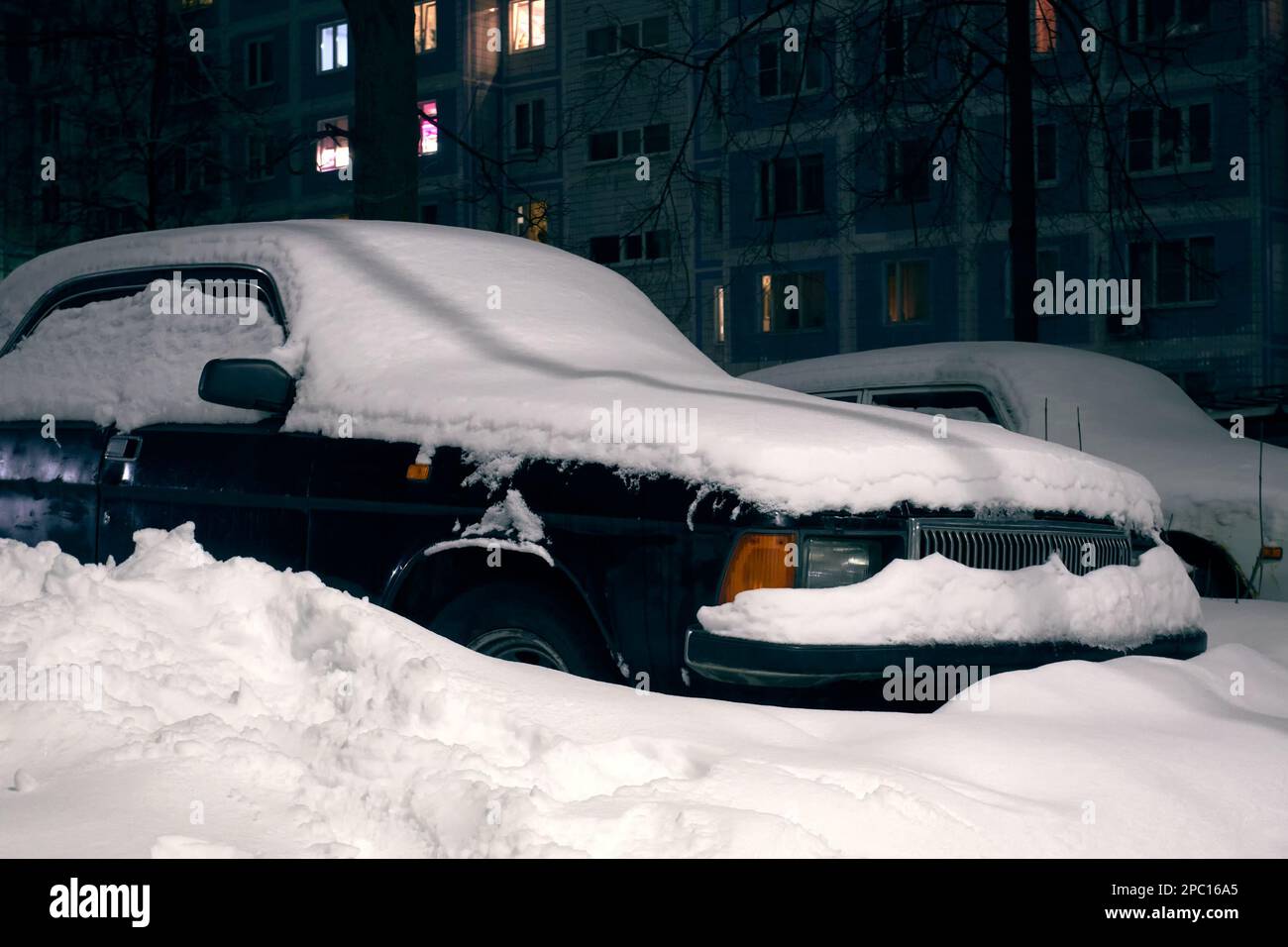 Snow covered car on the street at night Stock Photo - Alamy