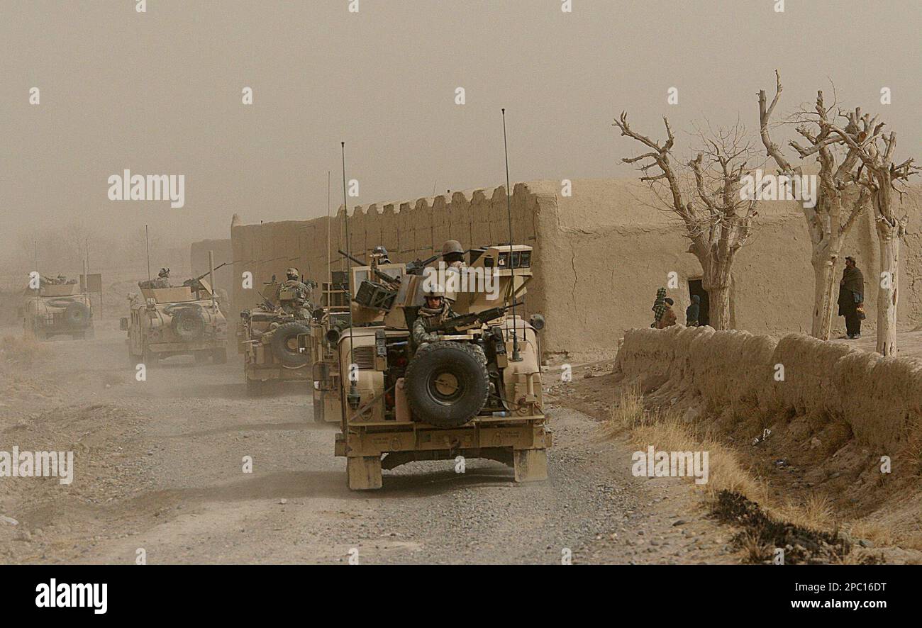 U.S. Special Force soldiers patrol in Humvee as villagers look on ...