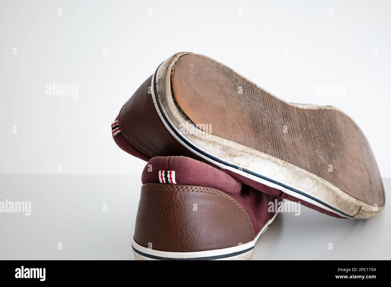 A pair of old, dirty, worn out men's shoes or sneakers isolated on ...