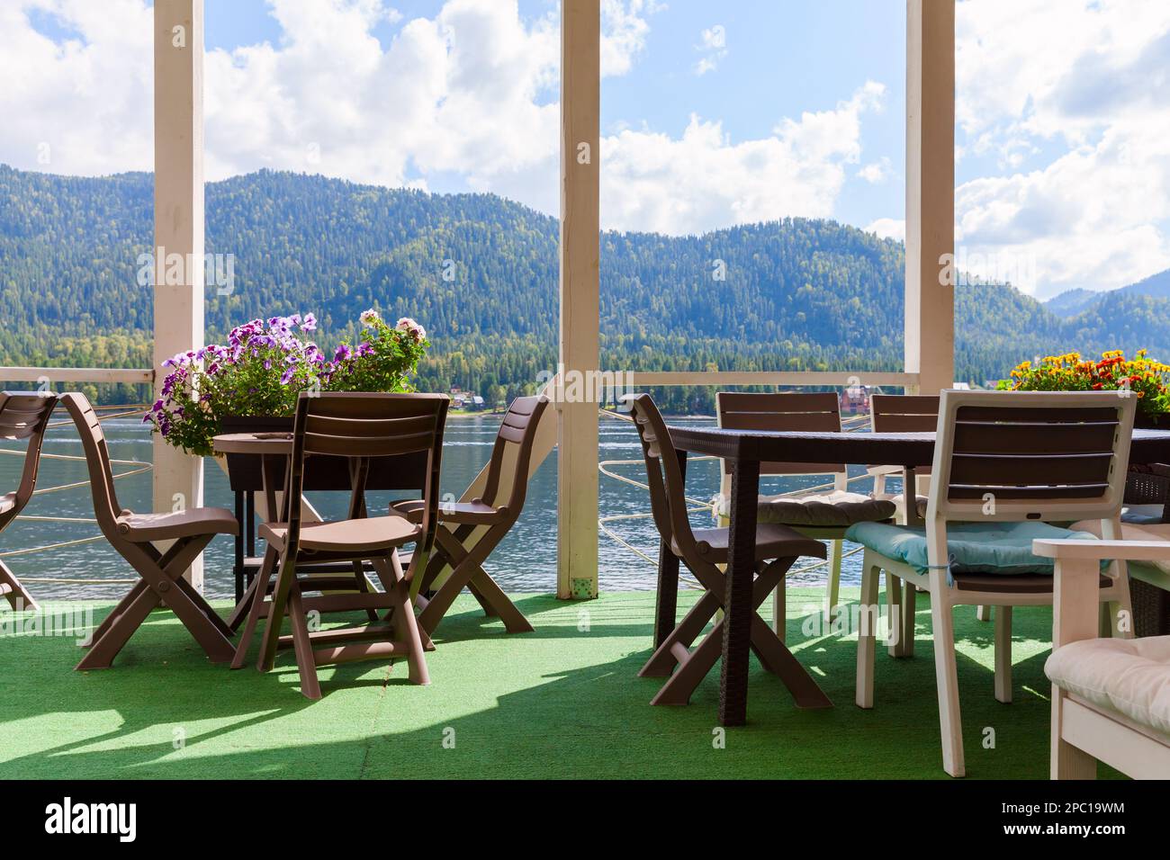 Outdoor furniture on a summer terrace, empty tables and chairs at a ...