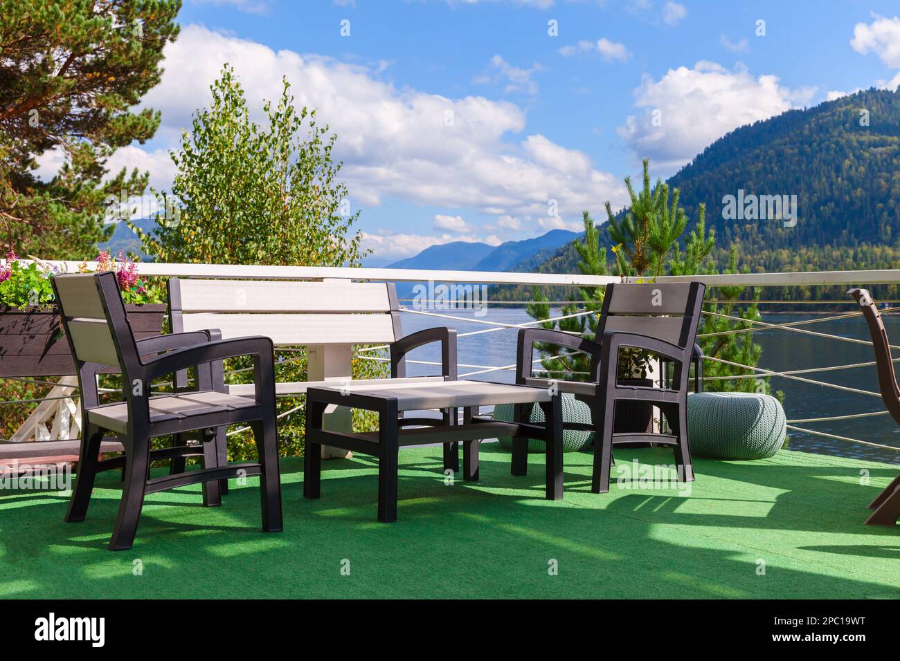 Summer terrace with outdoor furniture on a sunny day, empty tables and ...