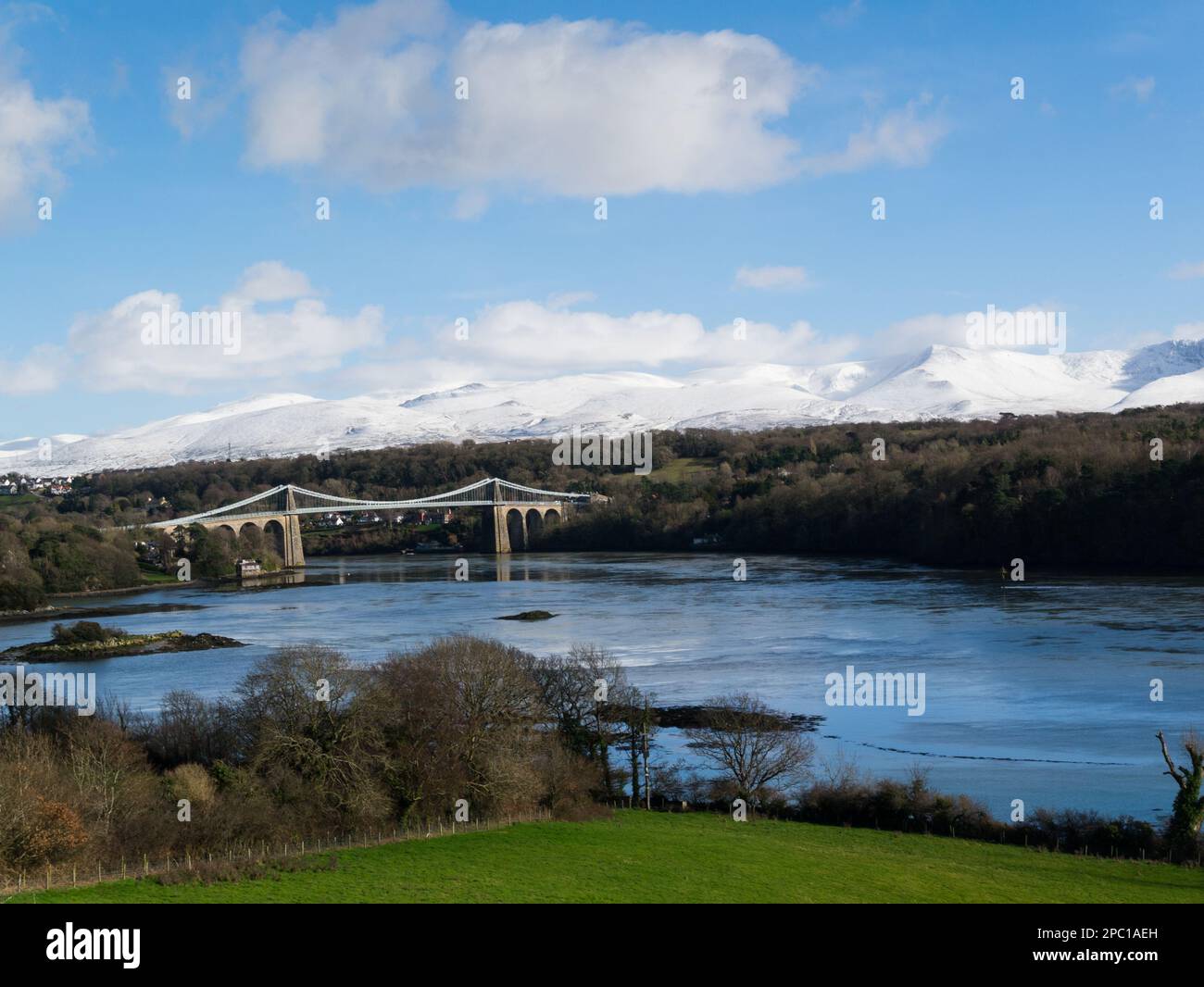 View across Menai Strait to Menai Suspension Bridge with snow covered ...