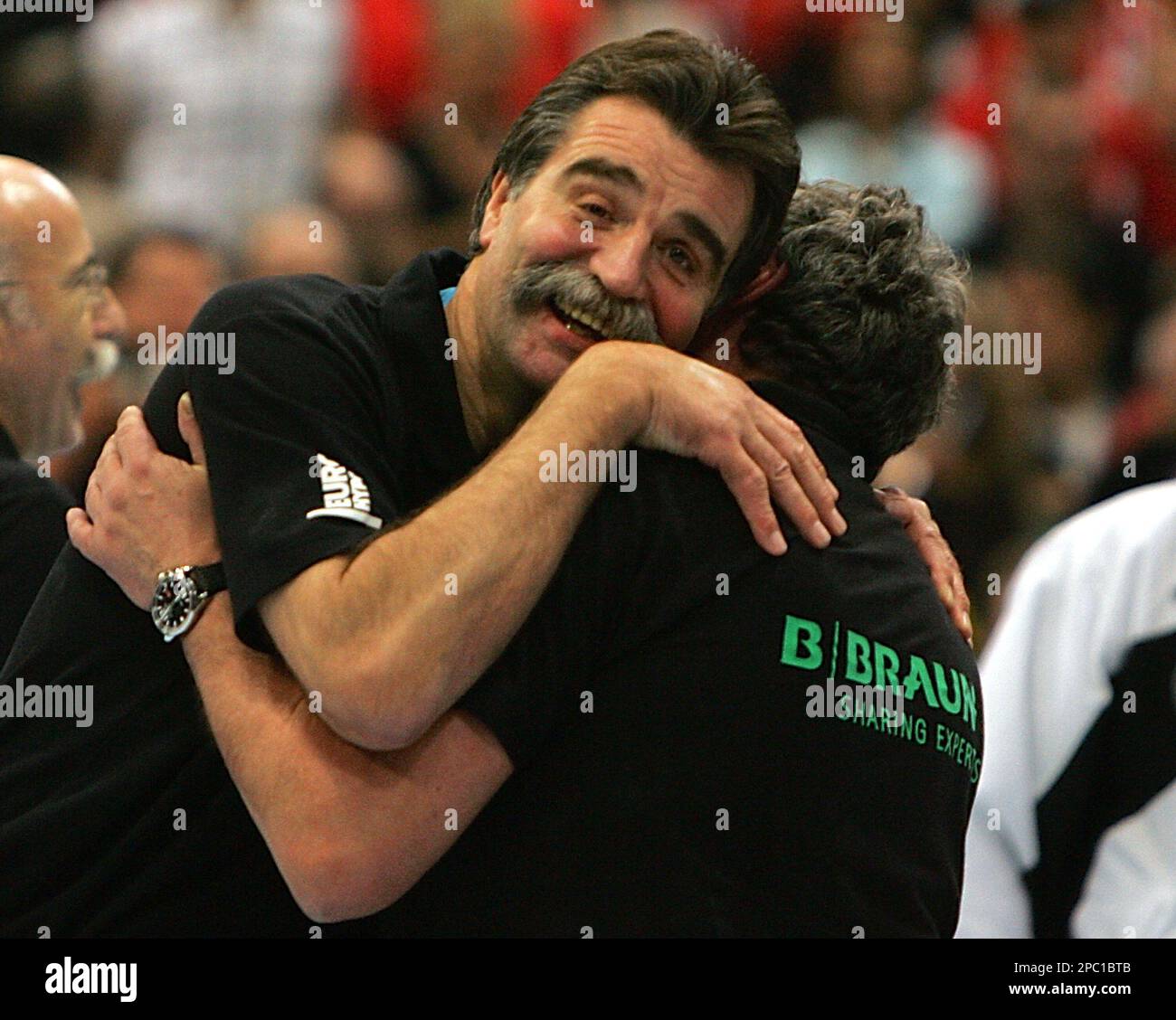 Germany's coach Heiner Brand embraces an unidentified assistant after ...