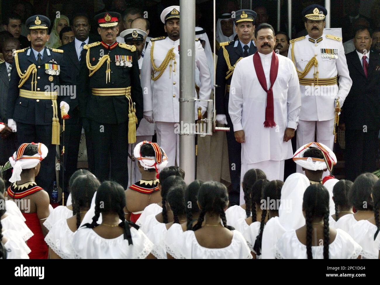 Sri Lankan President Mahinda Rajapakse, in a red neckwear, sings the ...