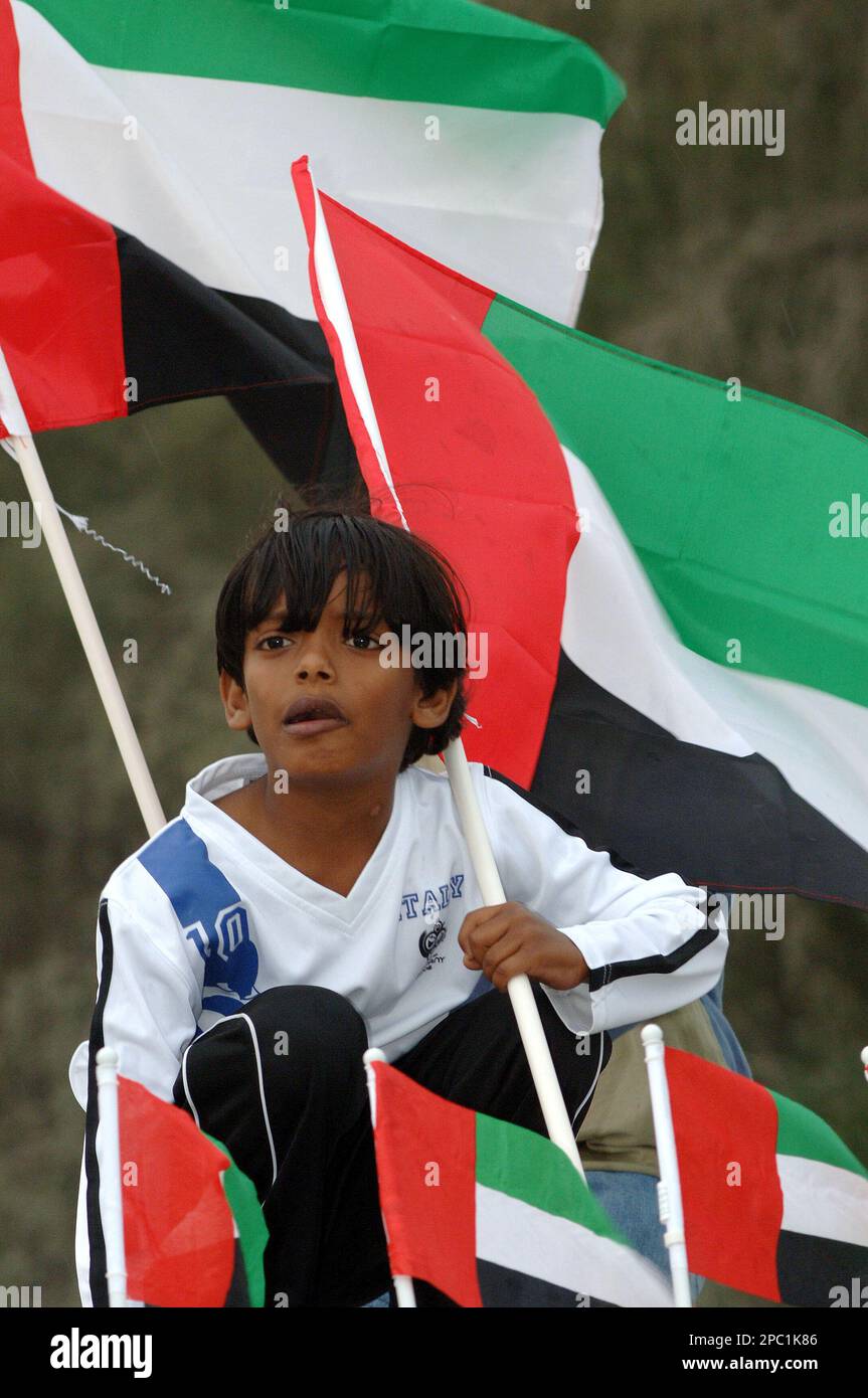 Young UAE soccer fan holds the UAE national flag as the UAE national ...