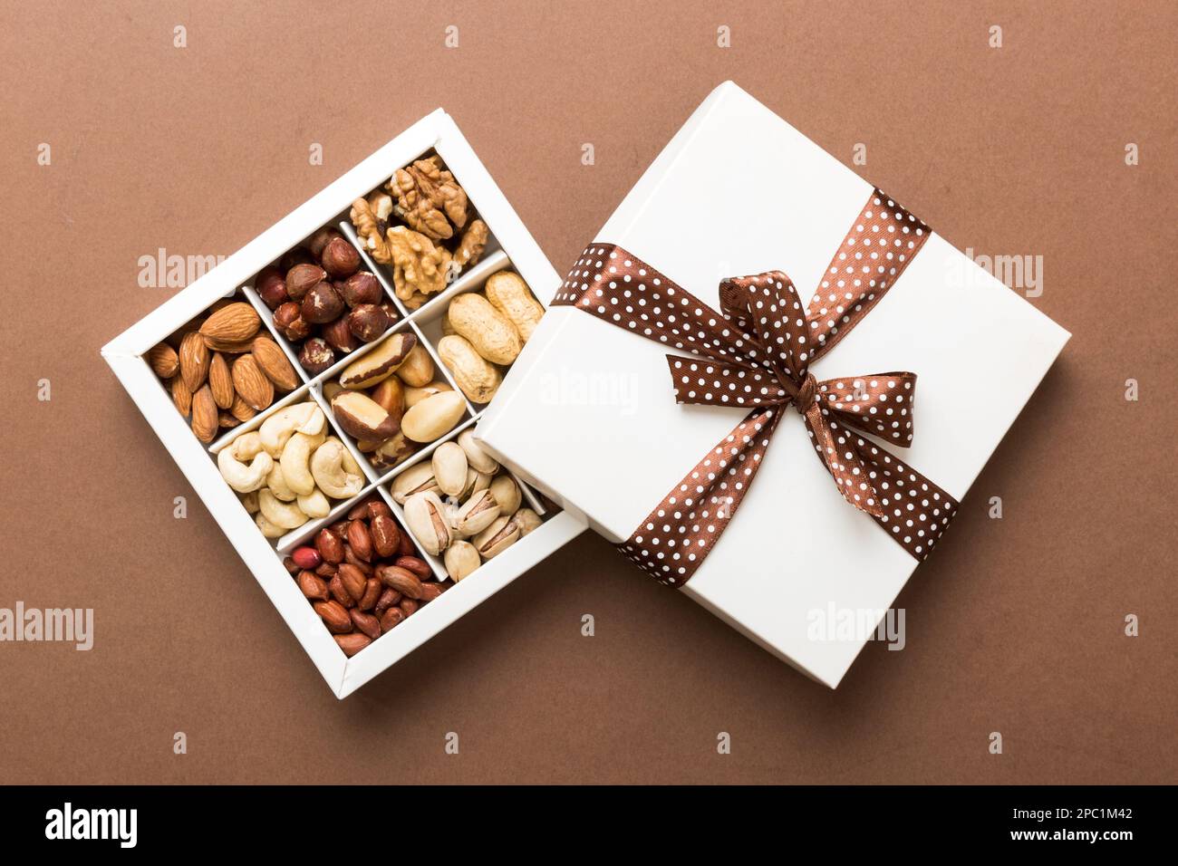 Various varieties of nuts lying in paper box on table background. Top ...