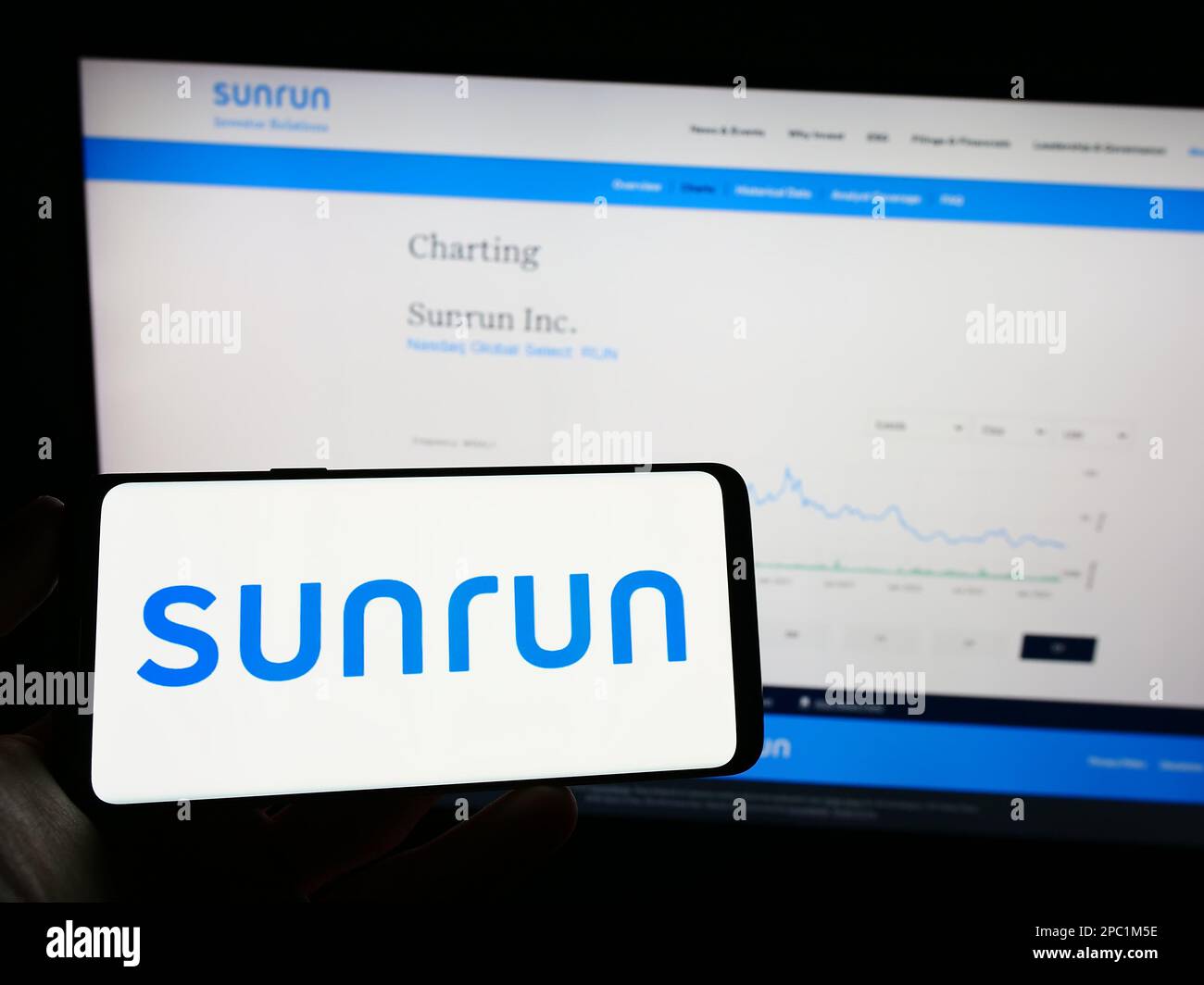 Person holding mobile phone with logo of American solar energy company ...