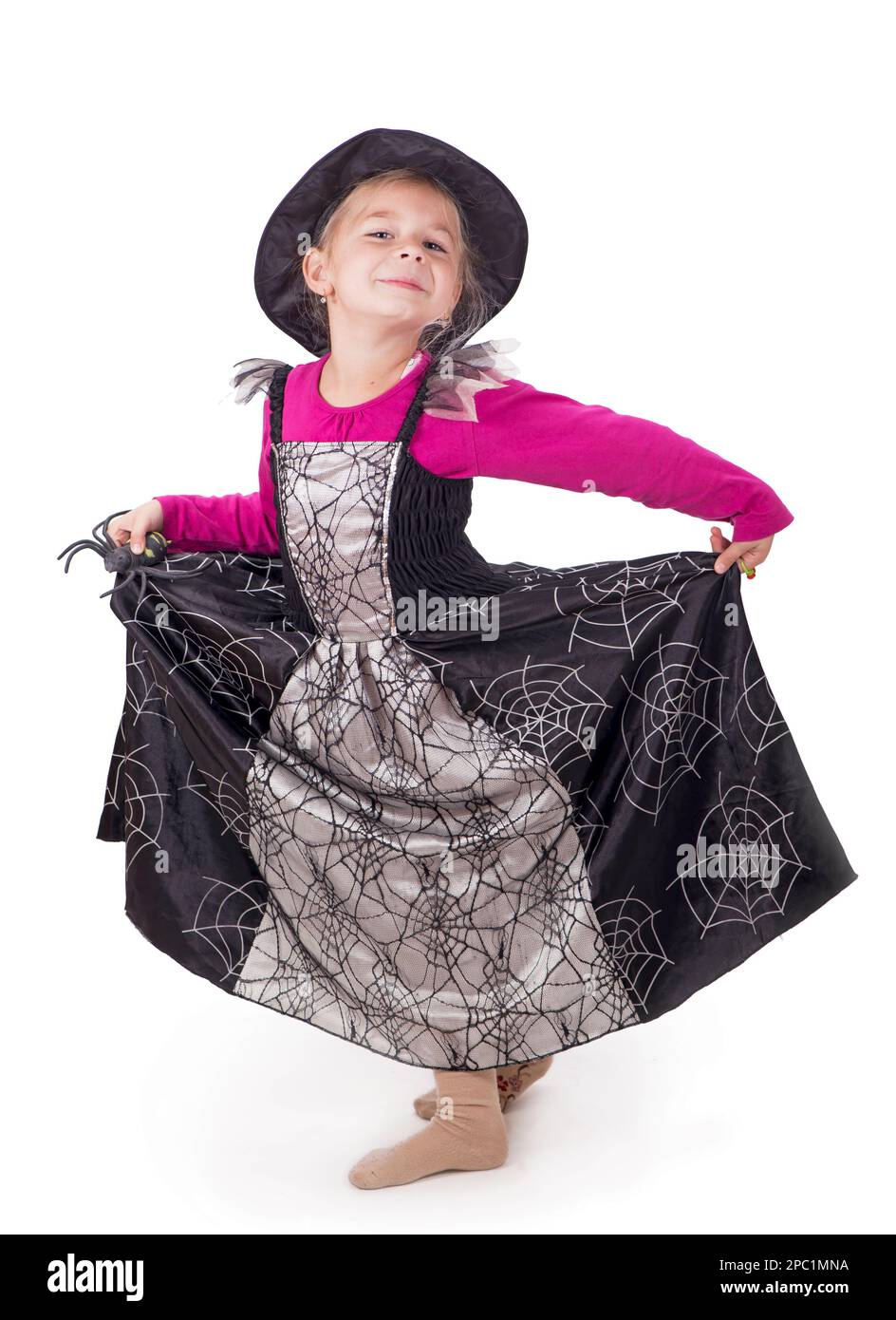 A beautiful girl in a witch costume, in a hat, with a spider in her ...