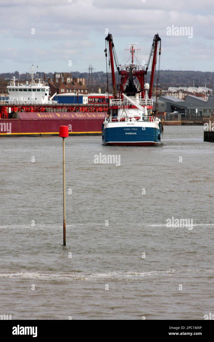 An incoming trawler waits whilst are barge is manouevered at Shoreham ...