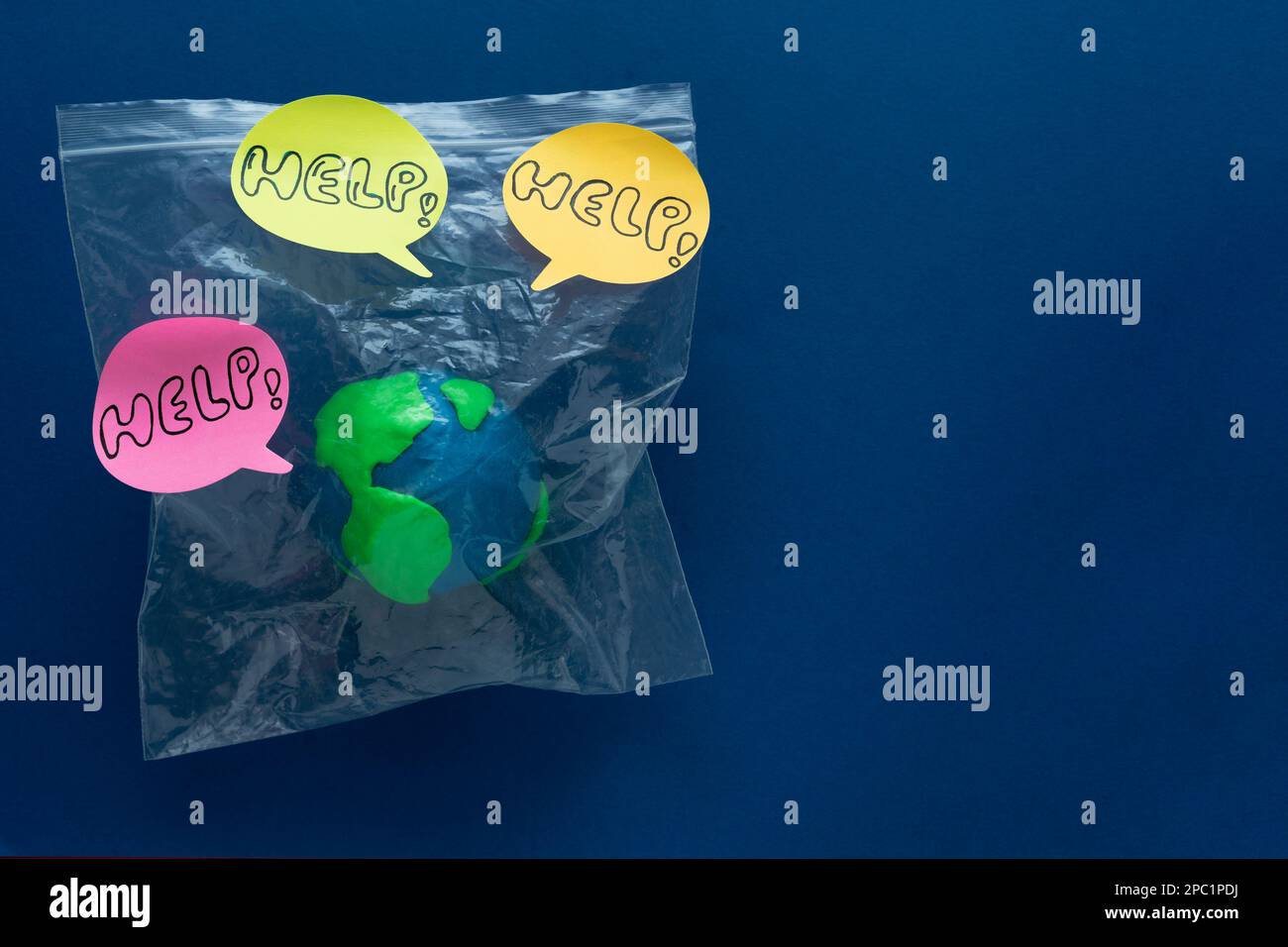 Earth Day. Globe enclosed in a plastic bag on blue background with HELP ...