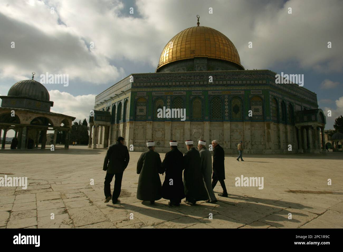 Palestinian Muslims walk by the Golden Dome of the Rock mosque in ...