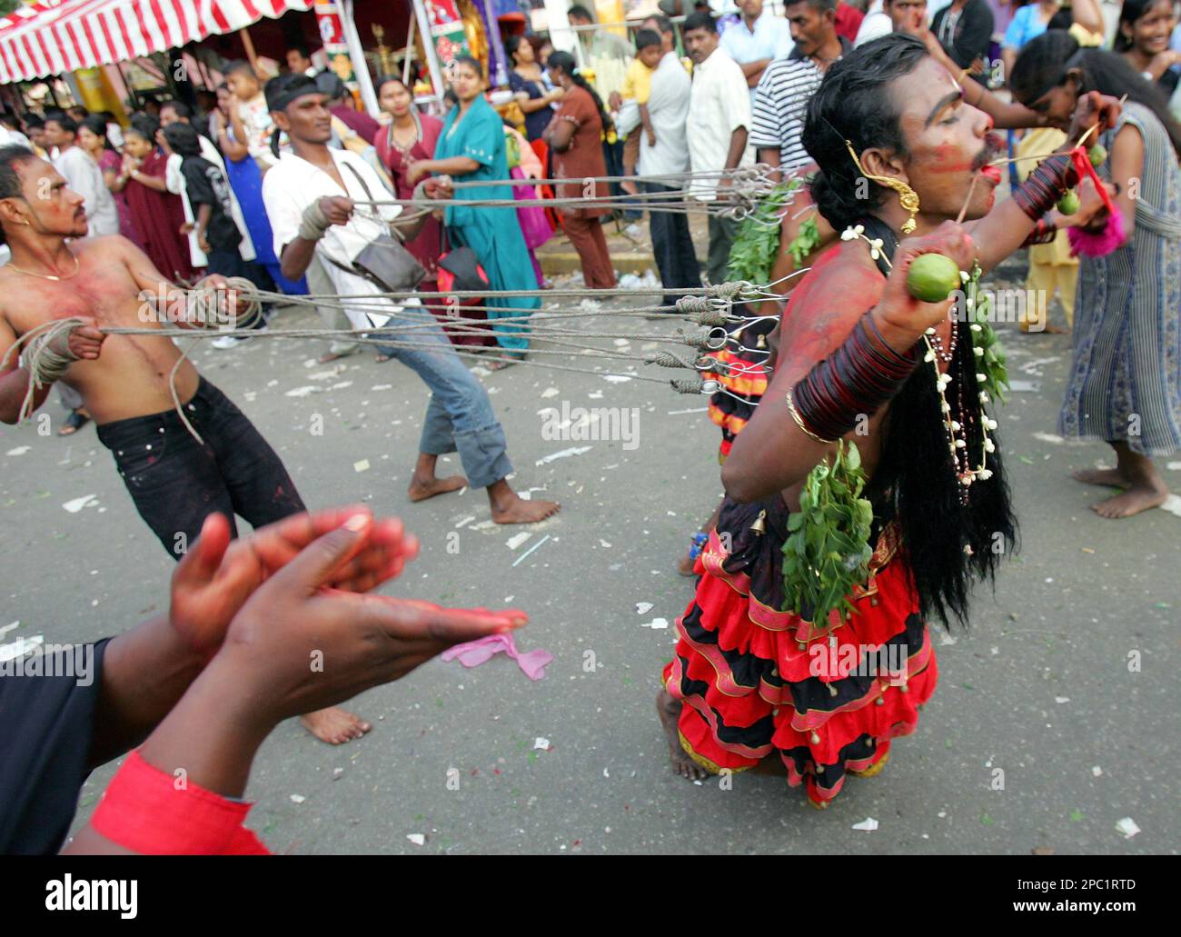 Malaysian Hindu men parade, getting himself pulled with hooks on his ...