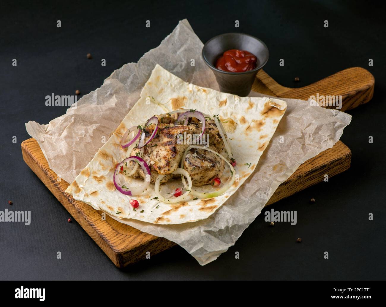 spicy grilled spare ribs on plate over dark stone background with copy ...