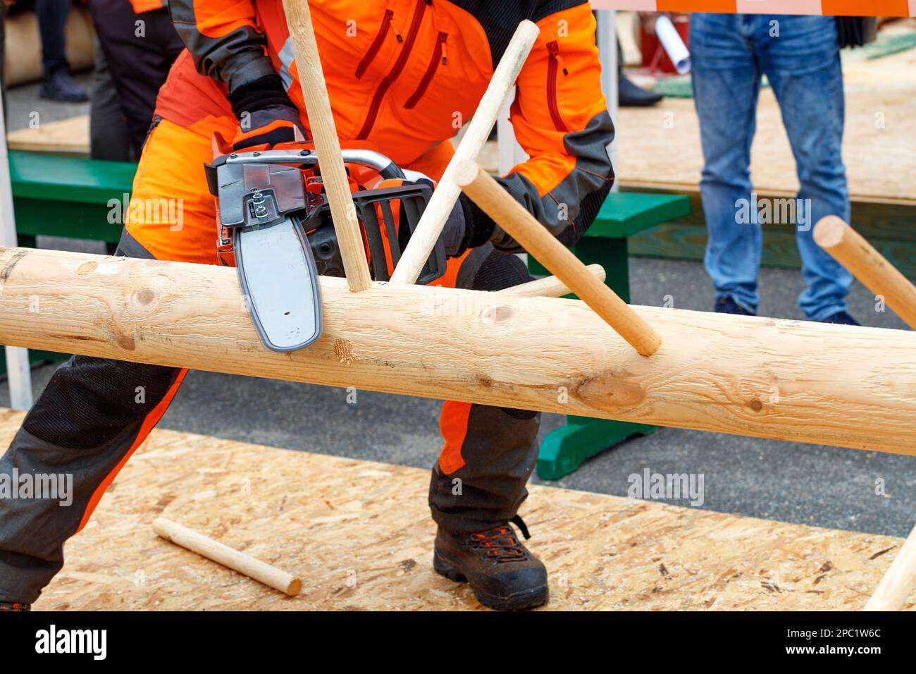 A lumberjack with a chainsaw at a competition to demonstrate ...