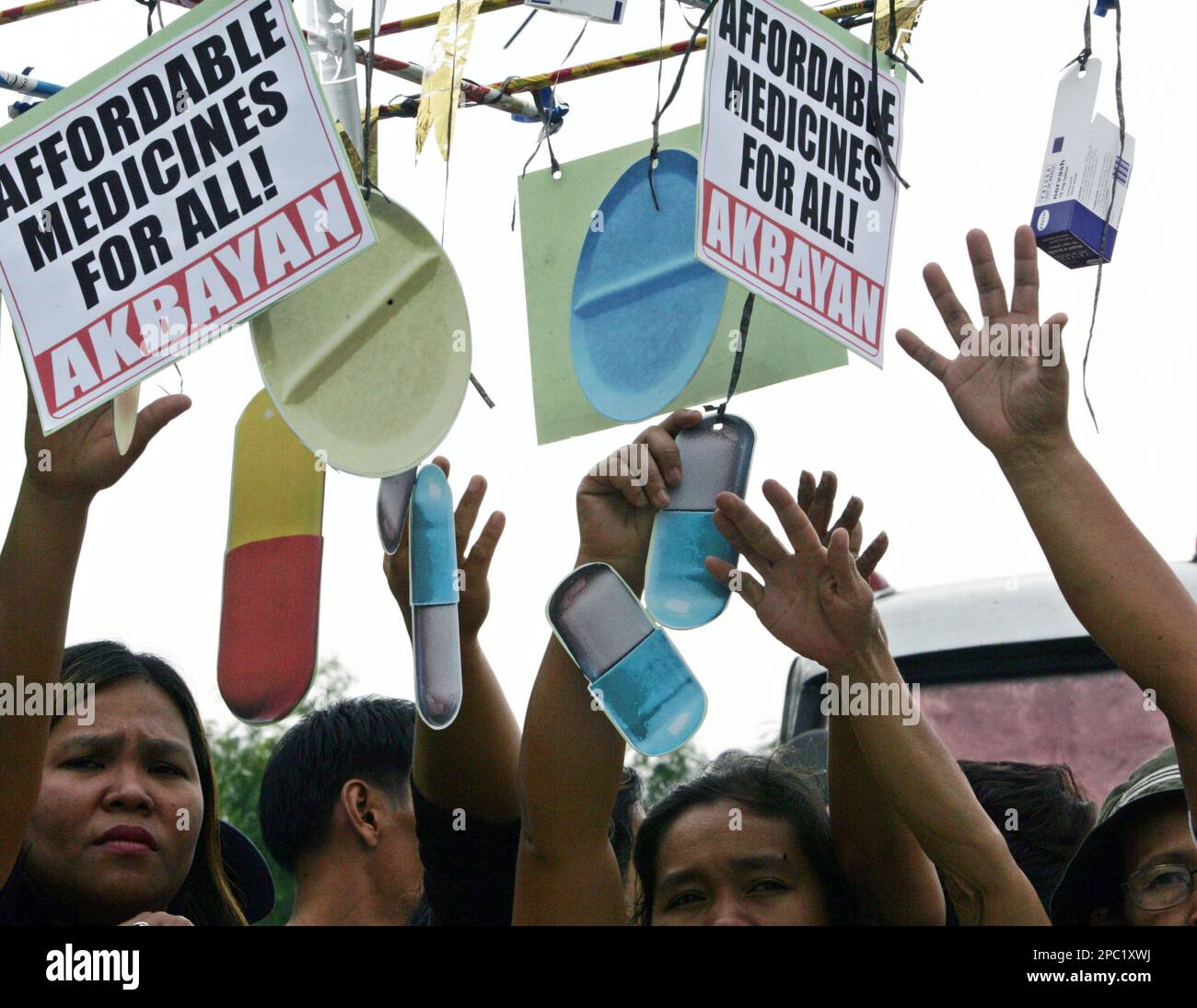 Protesters reach for medicine props being held by fellow protesters to ...