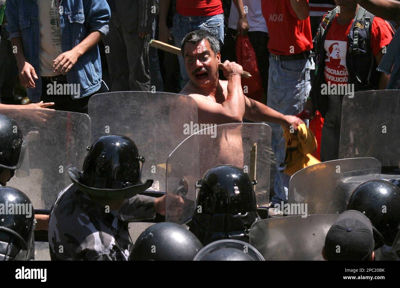 A demonstrator confronts riot police during a demonstration outside ...