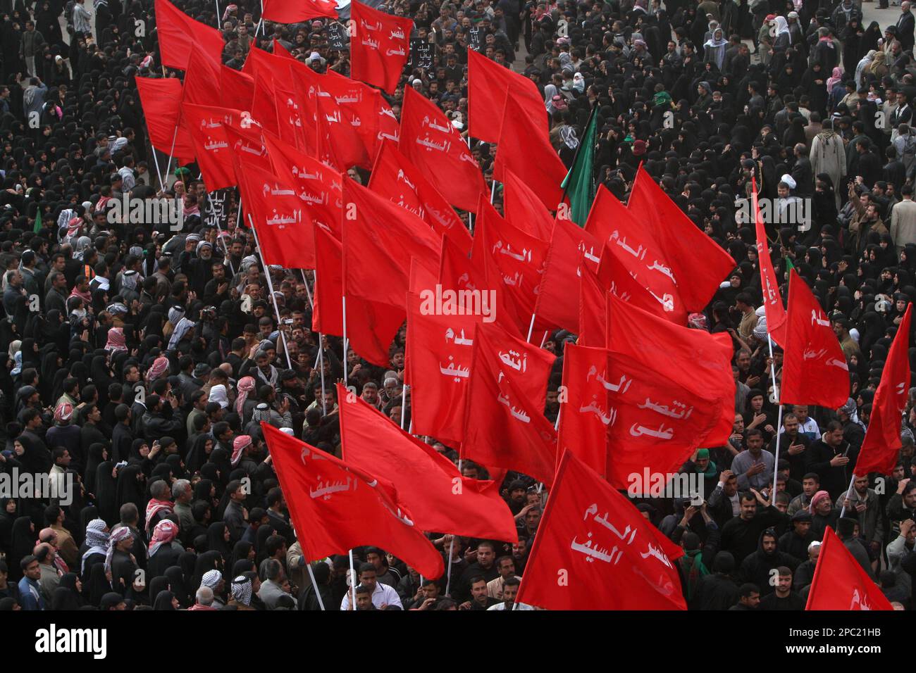 Iraqi pilgrims carry religious flags during Ashoura, the tenth day of ...