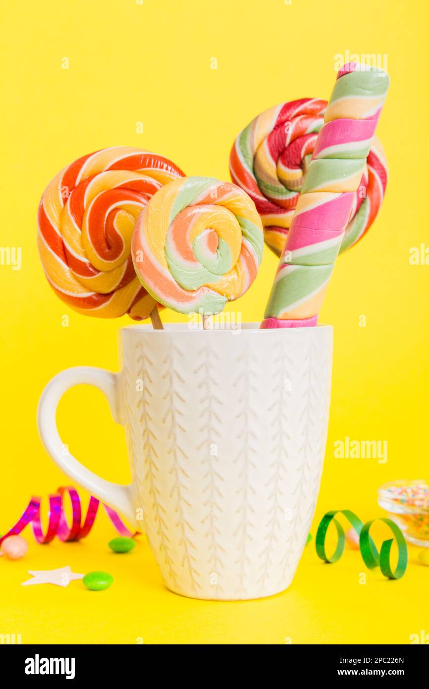 Colorful candies in cup on table on light background background. Large ...