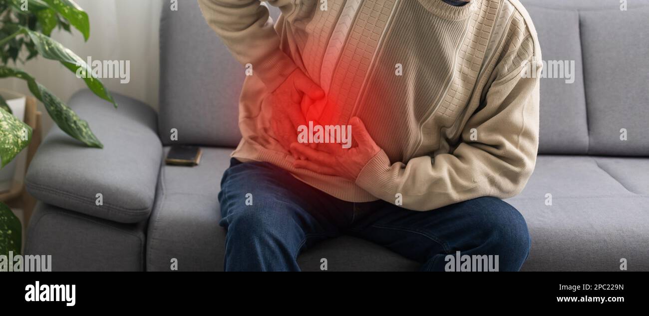 Man suffering from stomachache and holding hands on stomach with red ...