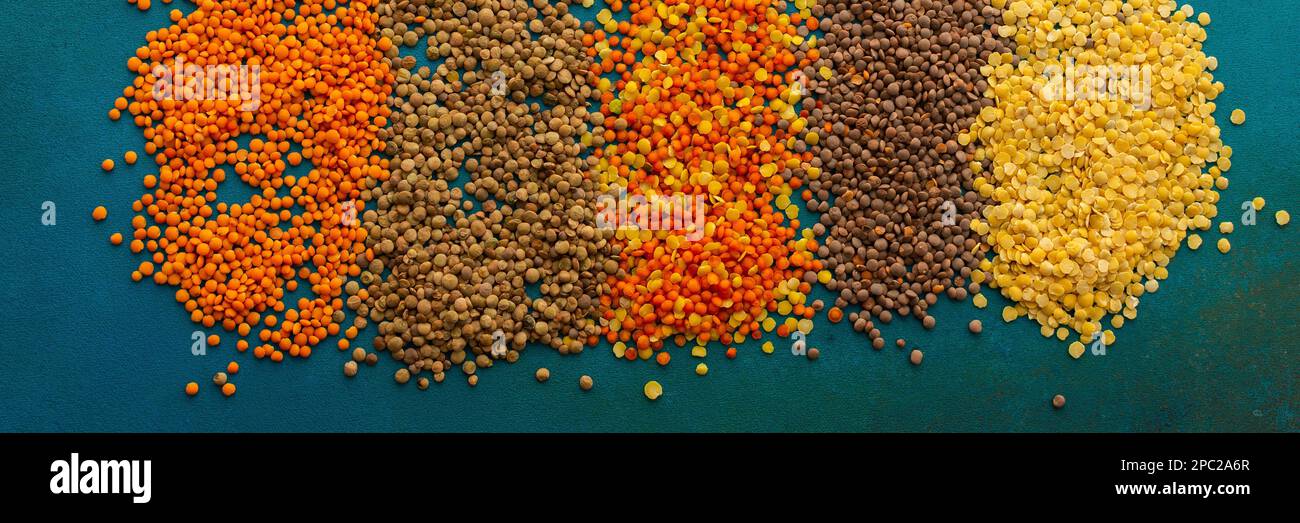 Multi-colored lentils on an emerald green background, scattered yellow ...