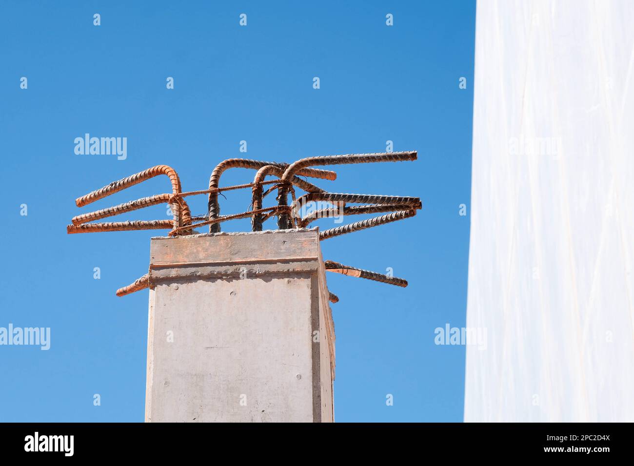 Cement column topped with exposed rebar at right angles and perfect ...