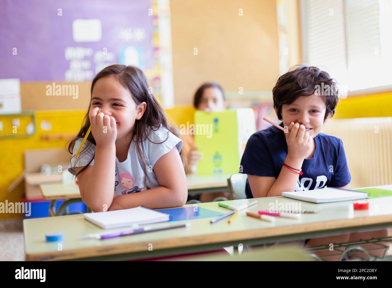 Two caucasian children having a fun time at school. They are happy and ...