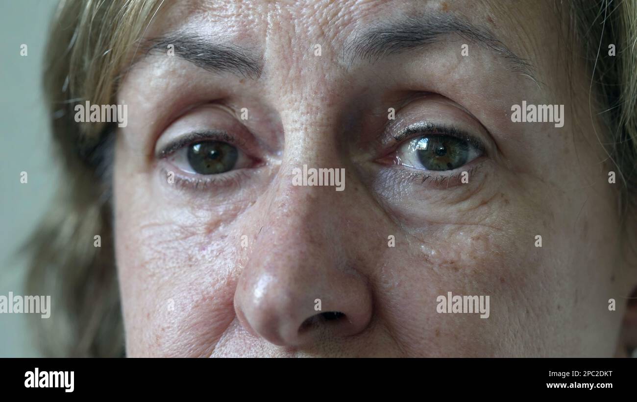 Mature woman eyes looking at camera with concerned expression. Macro ...